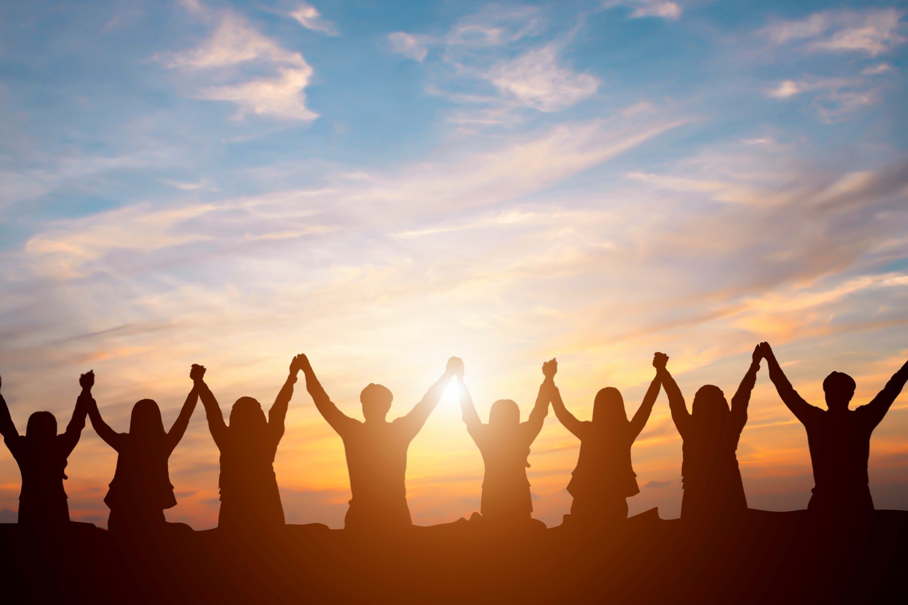 Silhouette of happy business team making high hands in sunset sky ...